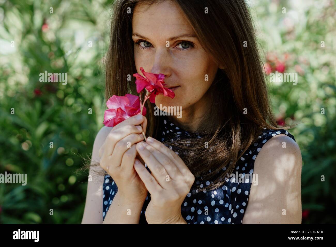Spanish girl sniffing pink roses Stock Photo - Alamy