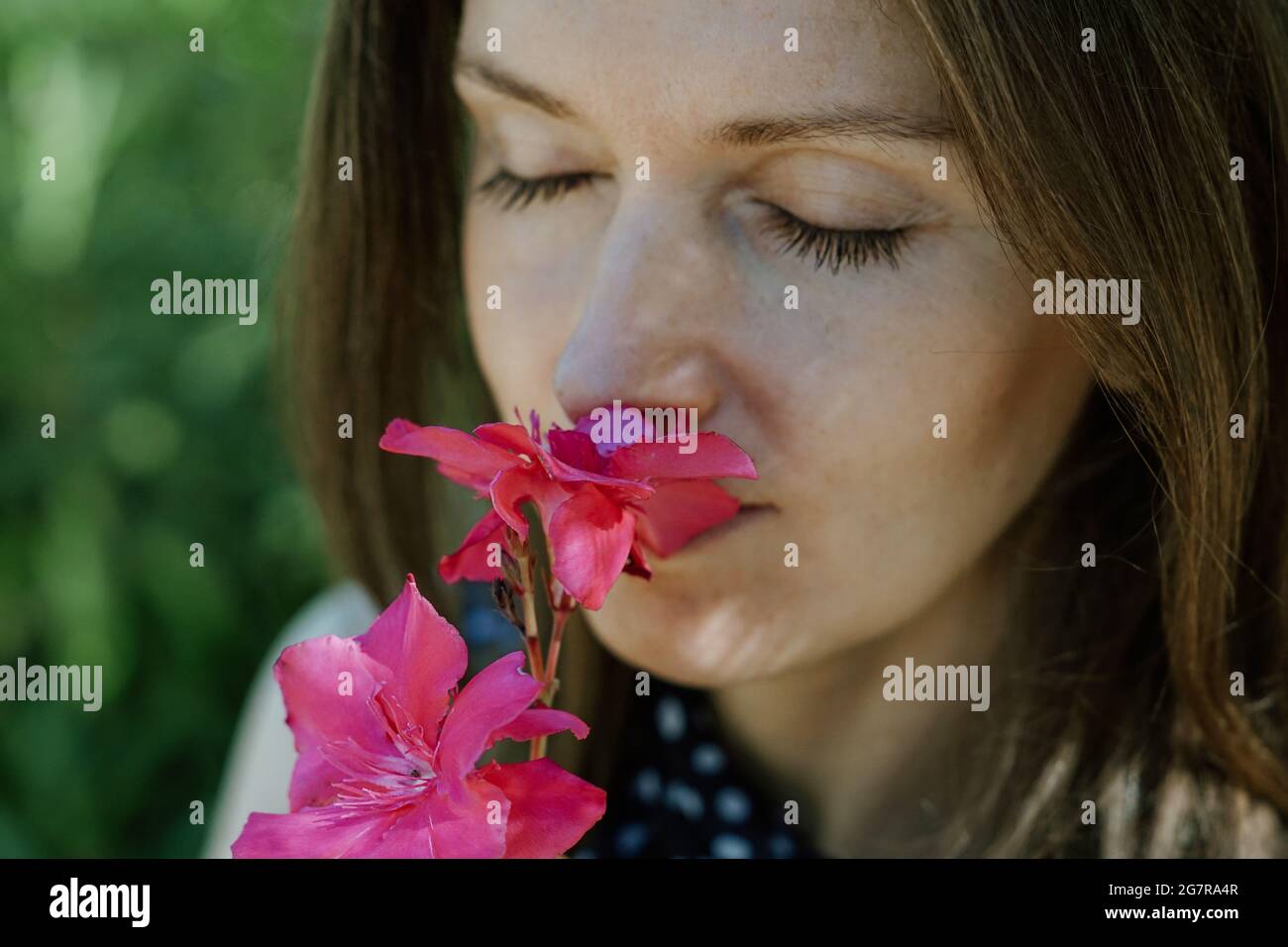 Spanish girl sniffing pink roses Stock Photo - Alamy