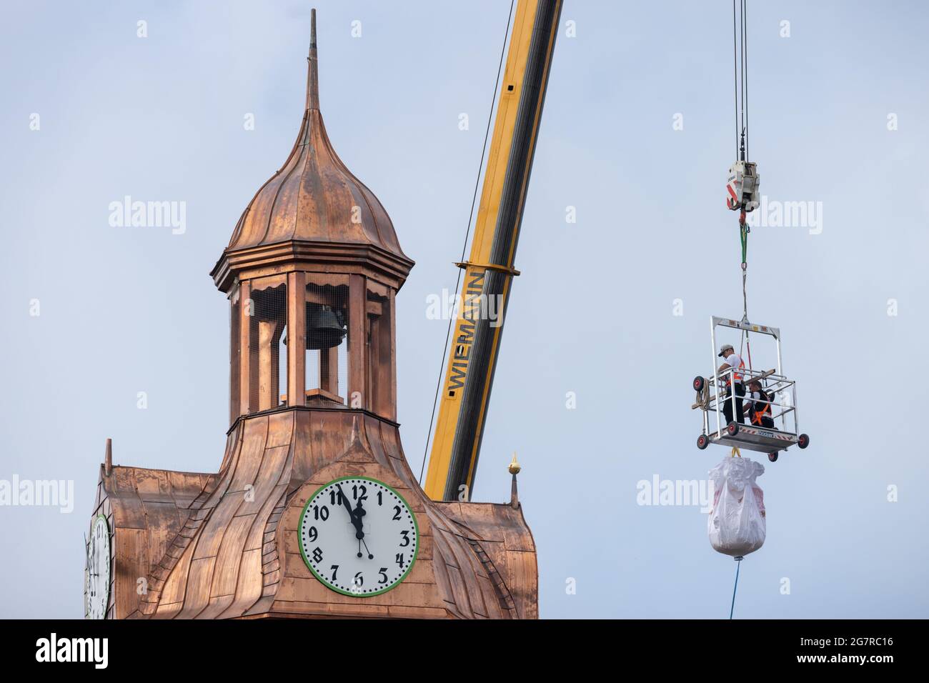 Ohrdruf, Germany. 16th July, 2021. Carpenters put the five gilded tower ...