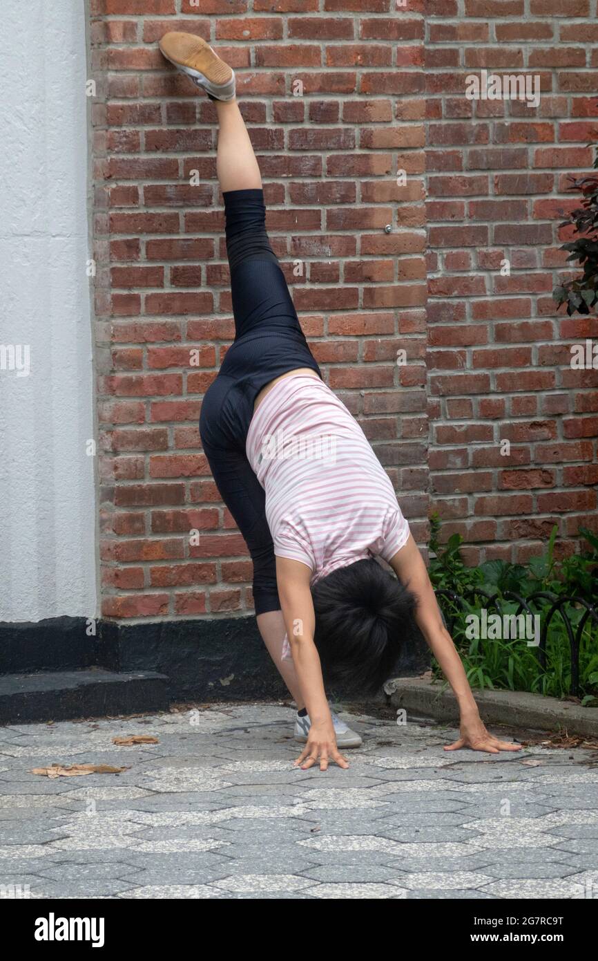 A nimble flexible young lady does rigorous stretching exercises in a ...