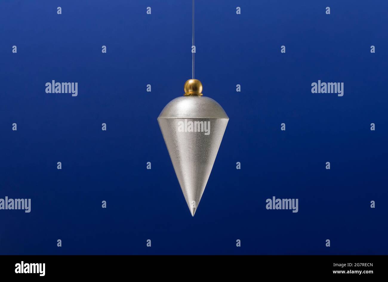 A silver pendulum hanging vertically Stock Photo - Alamy