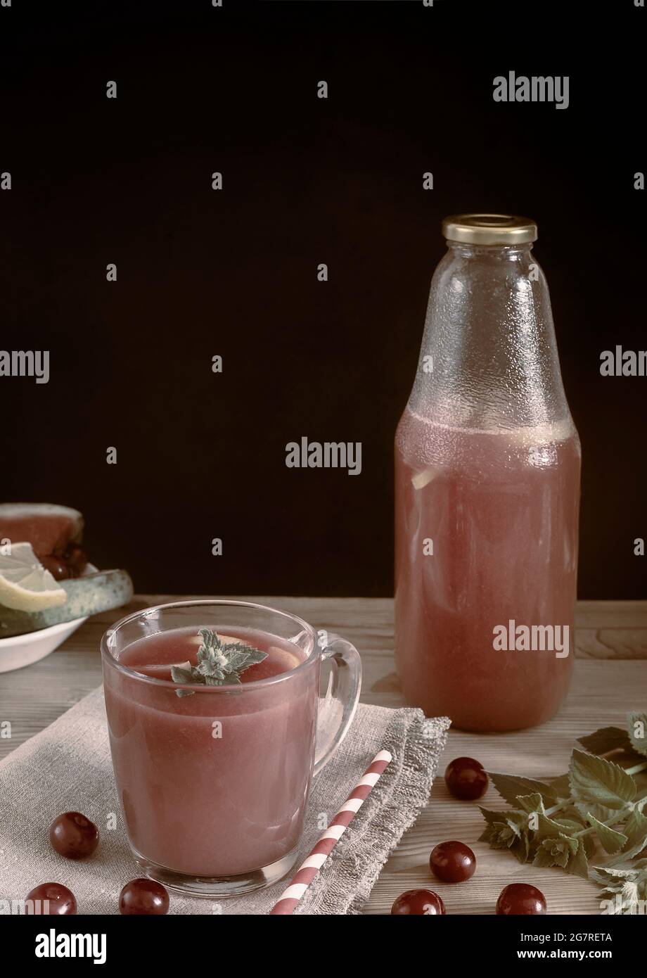 Fresh watermelon juice with cherries and lemon in a glass. Slices of ...