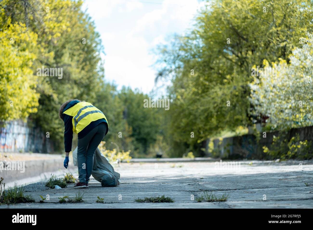 volunteers cleaning up city park or forest from plastic litter and ...