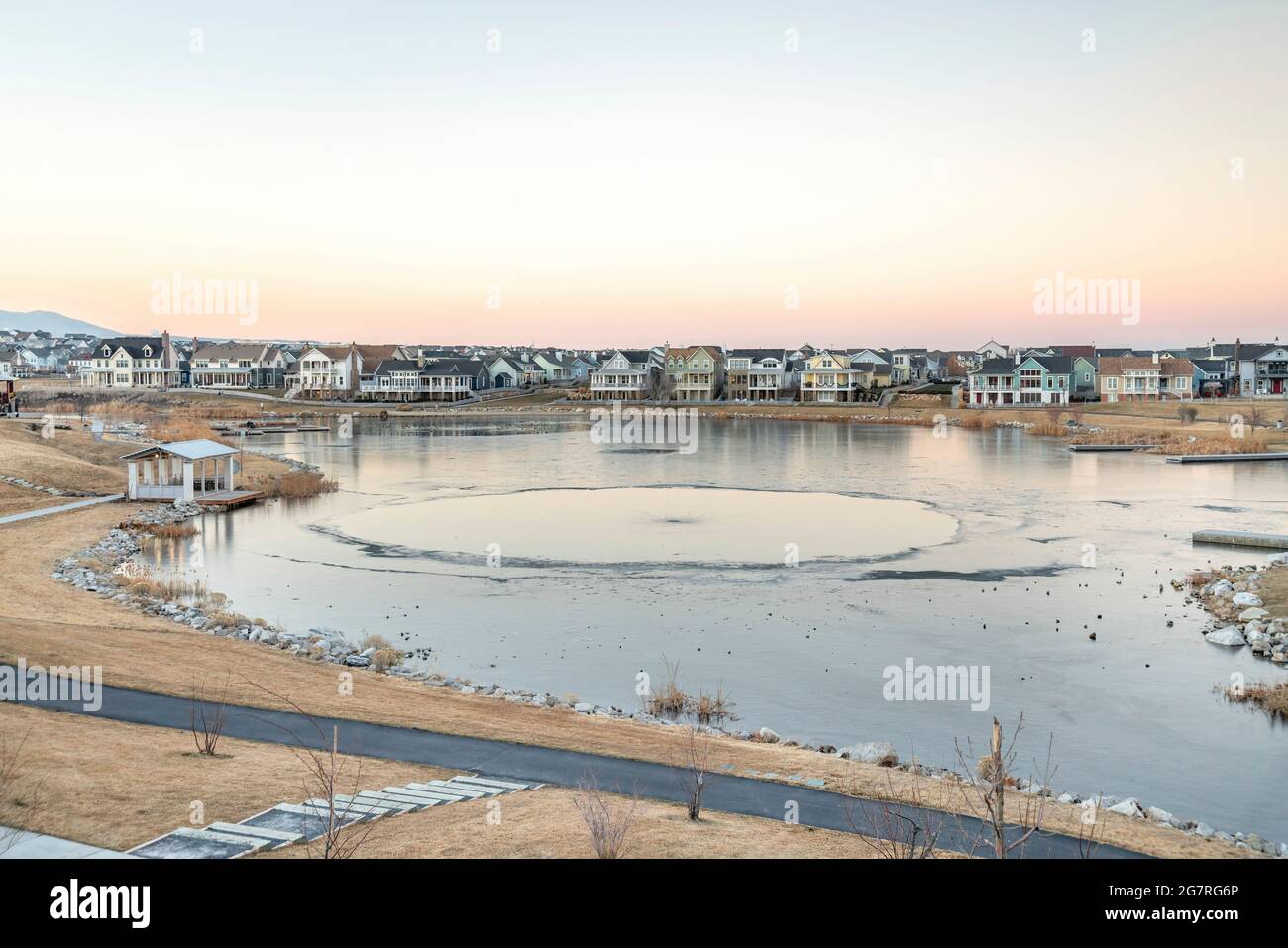 Lake in the middle of a residential community with concrete trails on ...