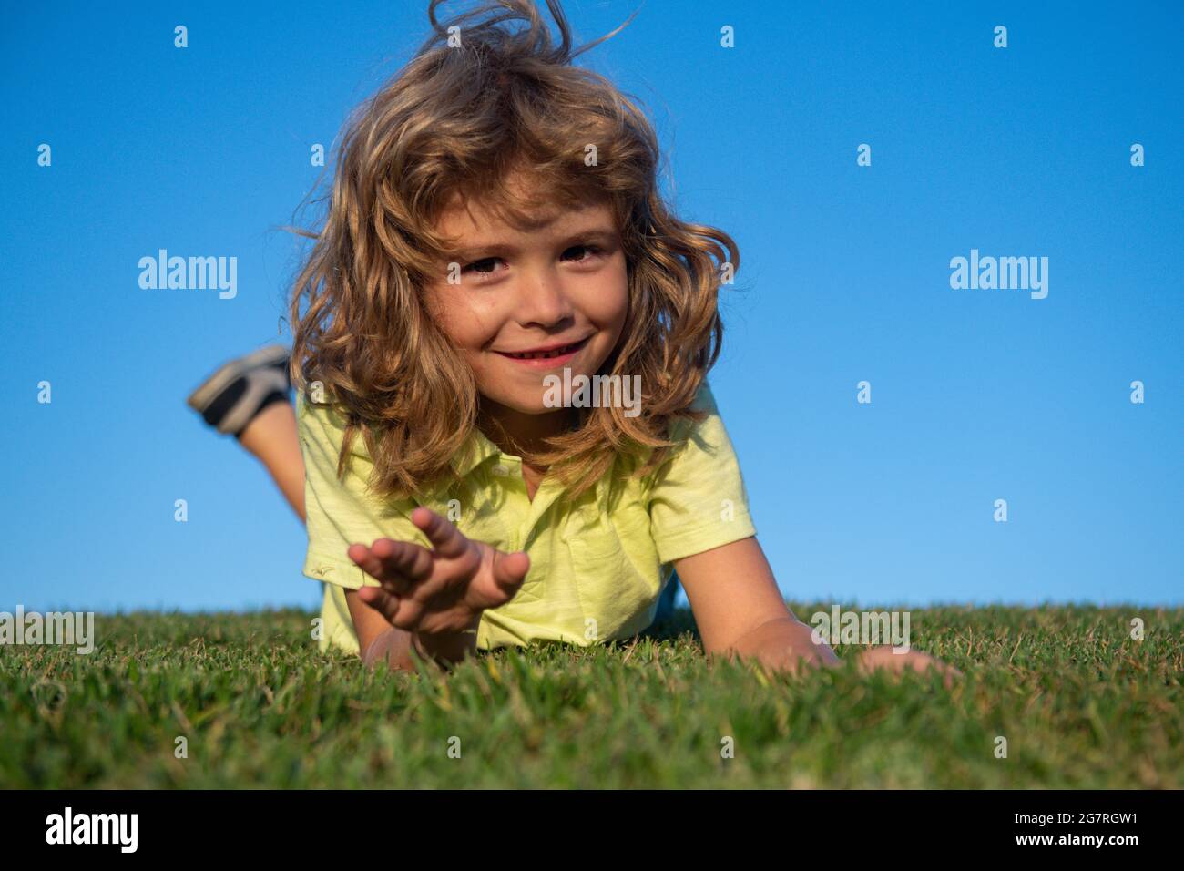 Portrait of a happy smiling child boy playing on grass field. Laughing ...