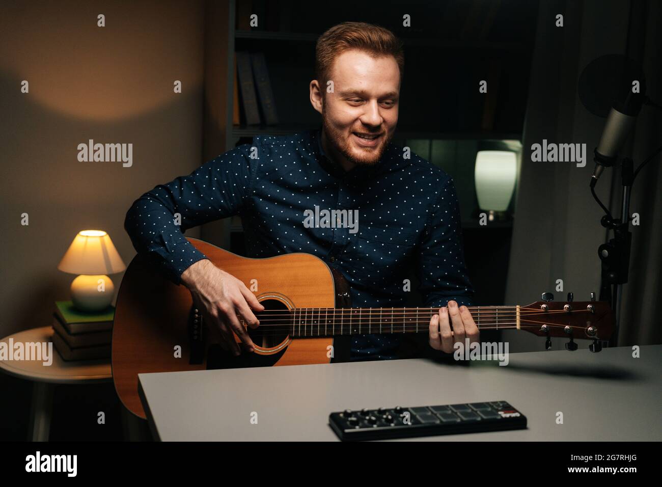 Portrait of guitarist singer man emotionally singing into condenser ...