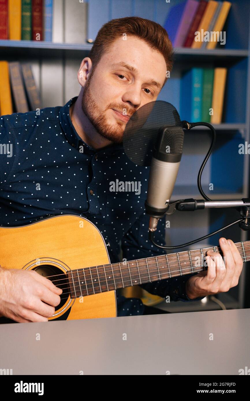 Vertical portrait of handsome guitarist singer man playing on acoustic ...
