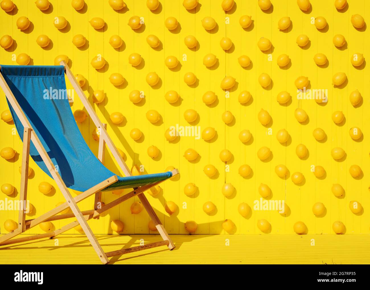 Blue beach chair on yellow background with lemons. Summer consept Stock ...
