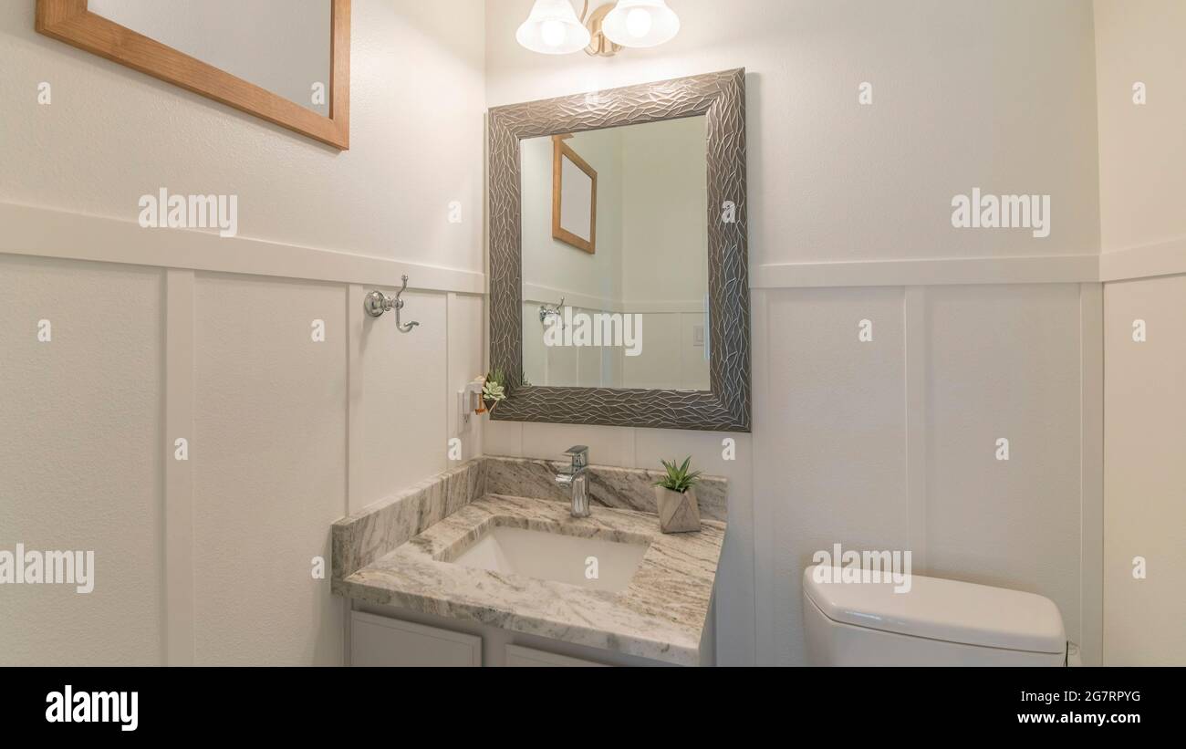 Pano Interior of a white painted bathroom with vanity sink and mirror ...
