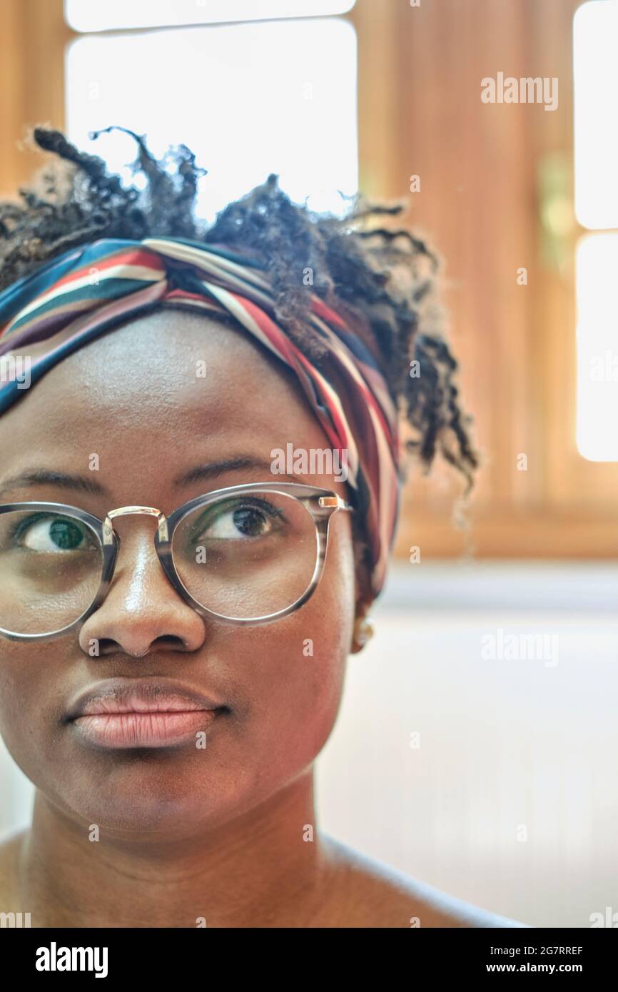Closeup portrait of a young black woman in glasses and afro hairstyle ...