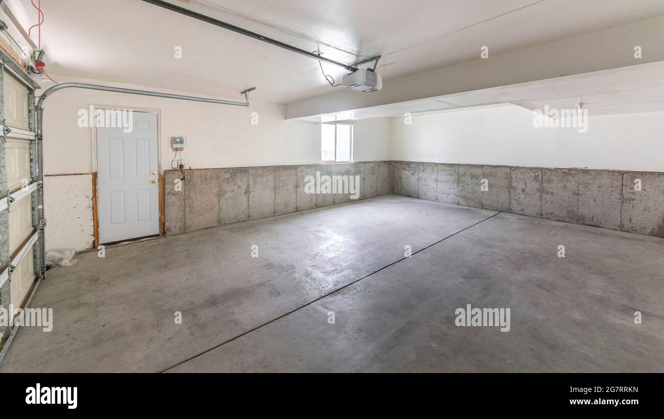 Pano Empty garage interior with concrete floors and an automatic door ...