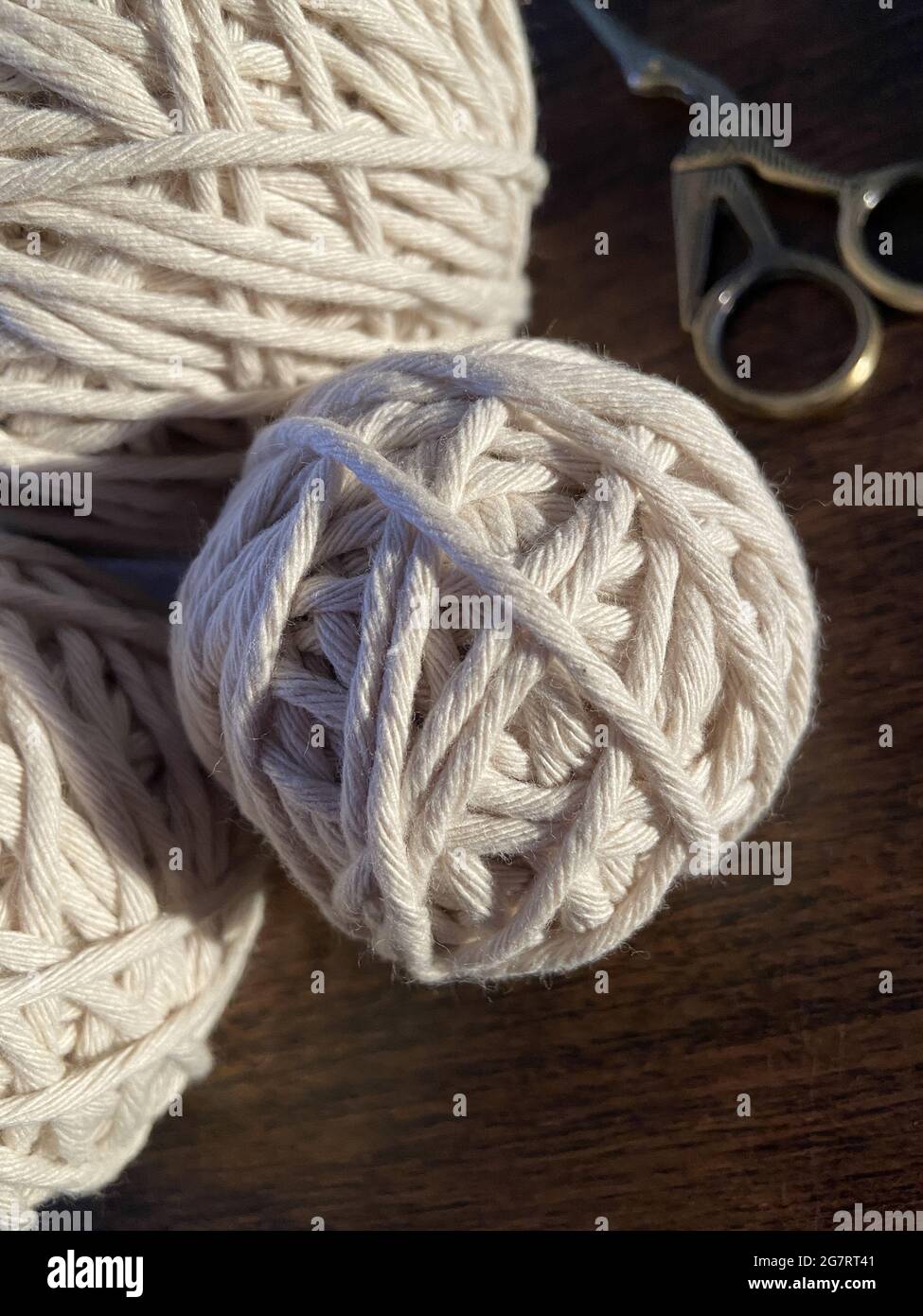 Close up of white skeins, cotton yarn on a brown wooden background ...