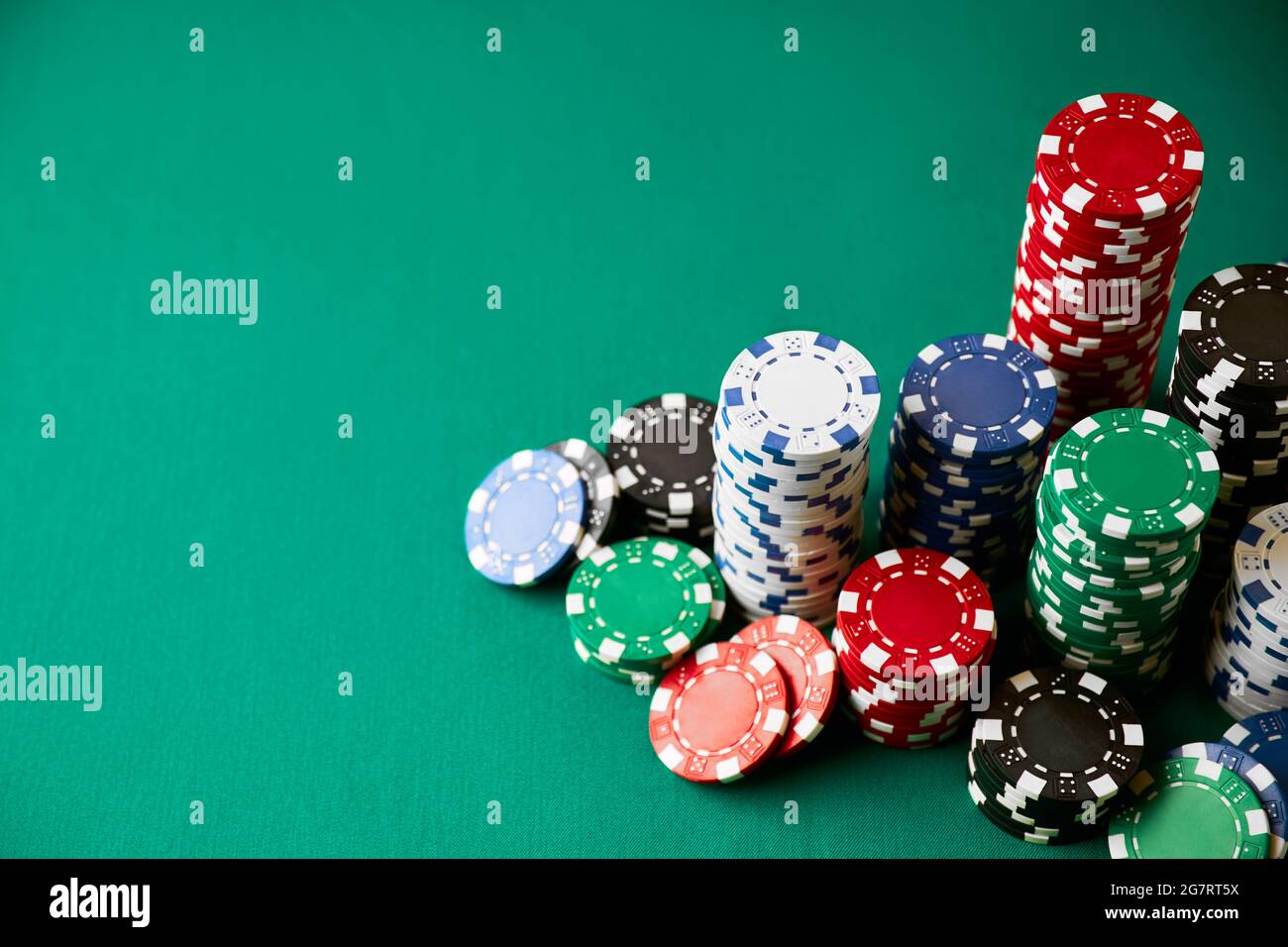 Stack of Casino gambling chips on green table Stock Photo - Alamy