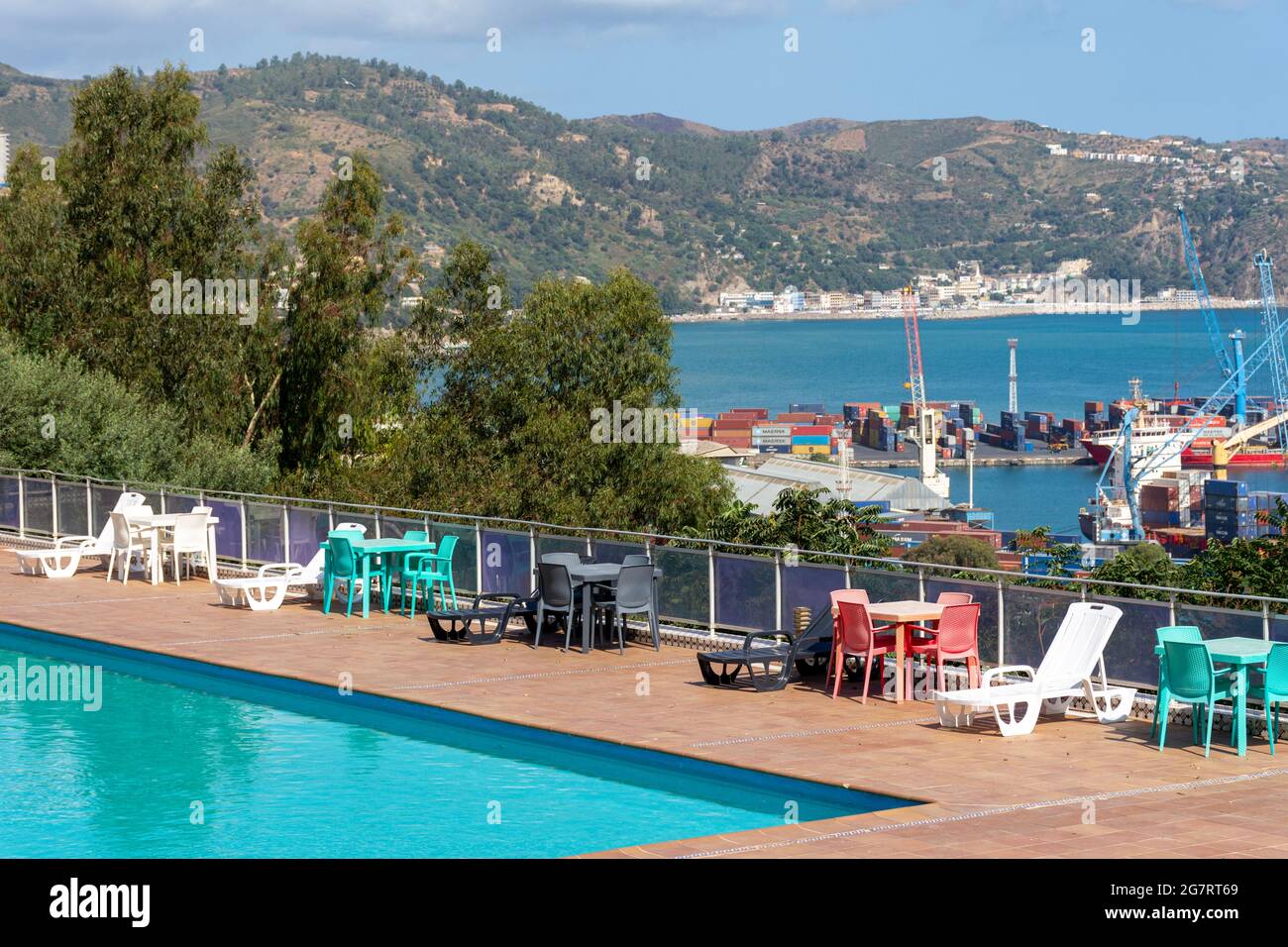 Plastic chairs with tables and sun loungers near the pool Stock Photo ...