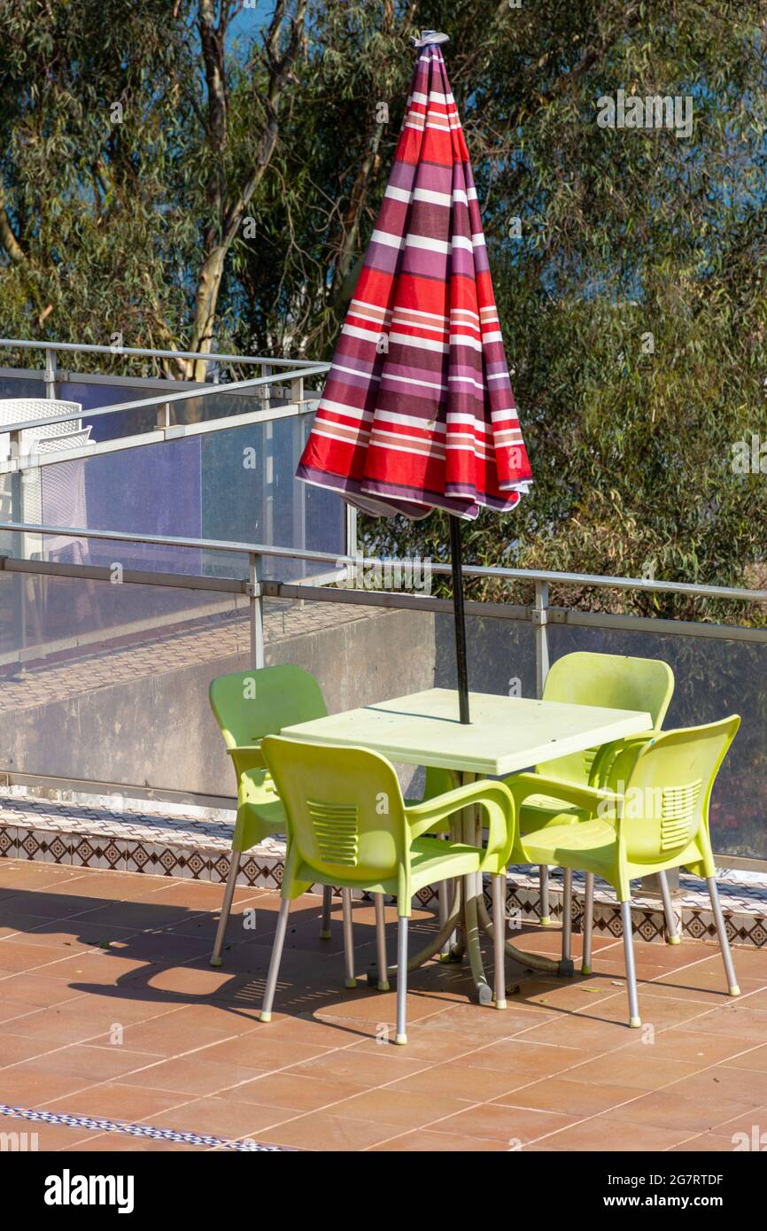 Colorful parasol with green plastic chairs Stock Photo - Alamy