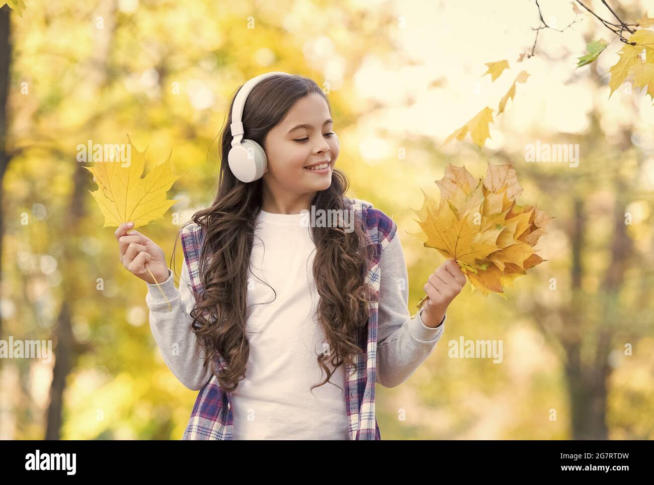 happy teenage kid listen music wearing headphones in autumn forest with ...