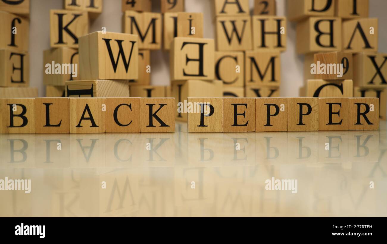 Black pepper word created from wooden letter cubes. Gastronomy and ...