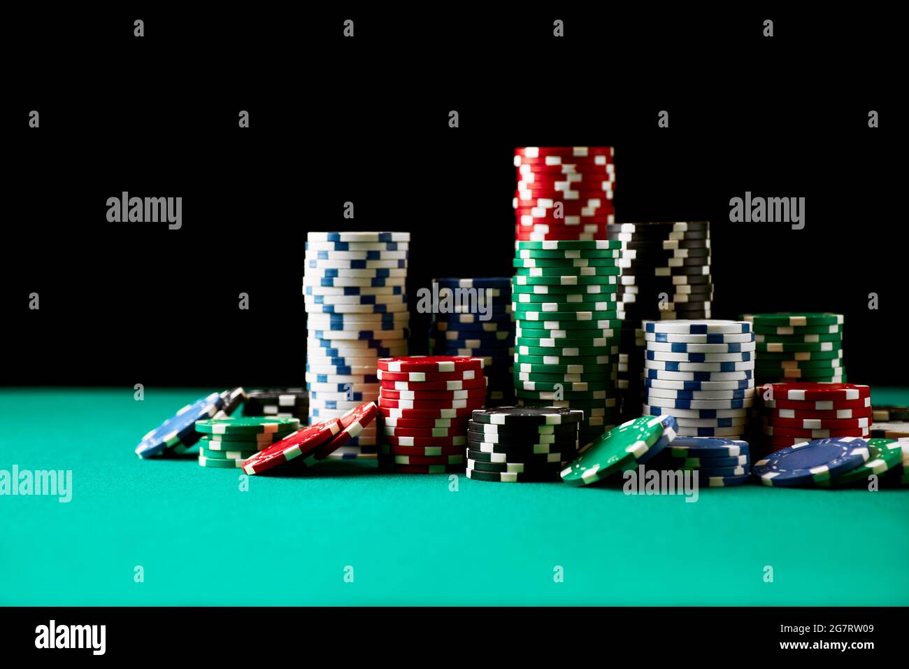 Stack of Casino gambling chips on green table Stock Photo - Alamy