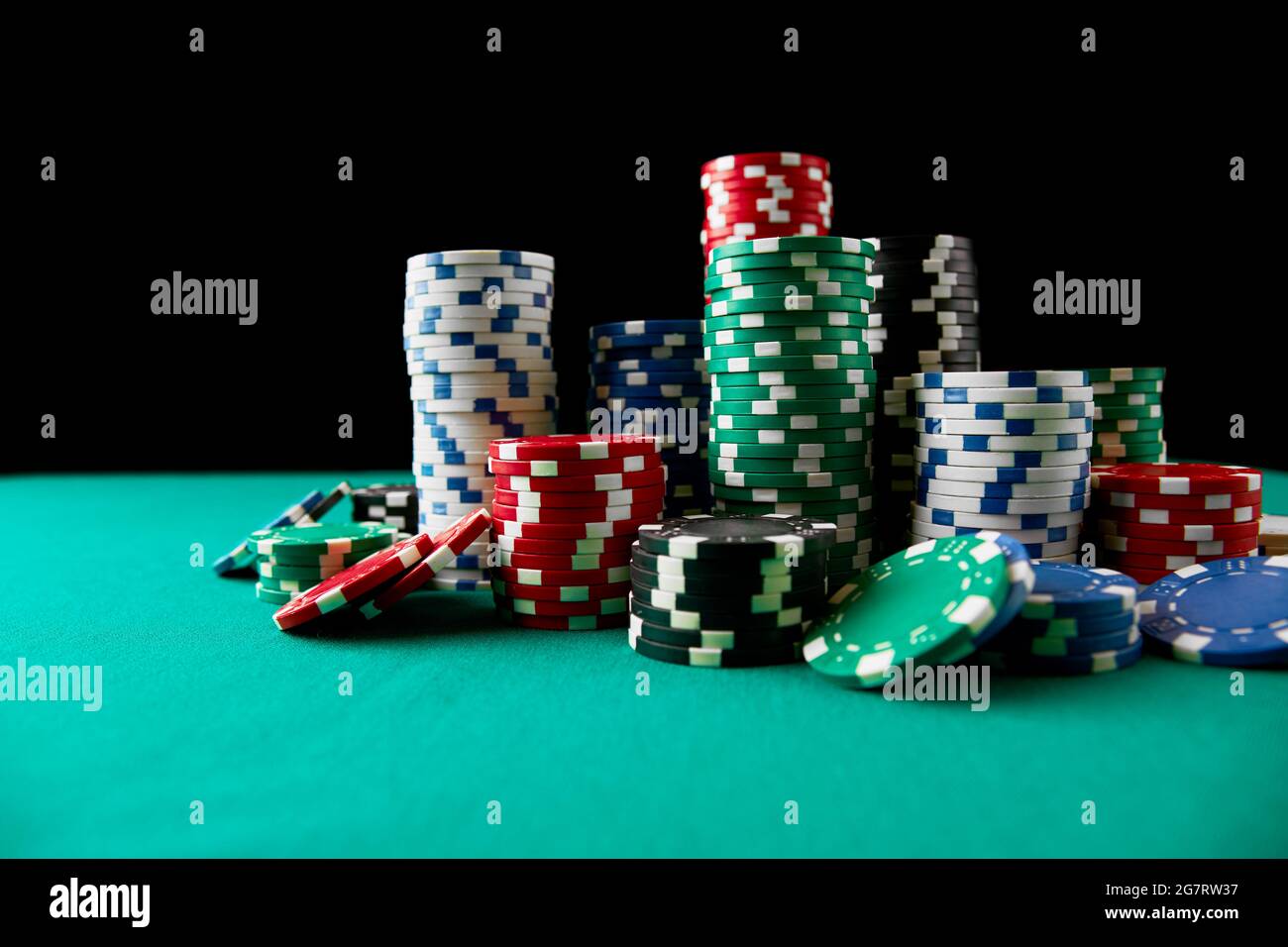 Stack of Casino gambling chips on green table Stock Photo - Alamy