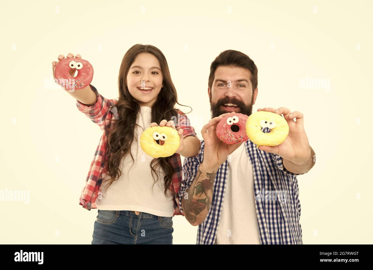 Sweet tooth. Girl child and dad hold glazed donuts. Cheerful family ...