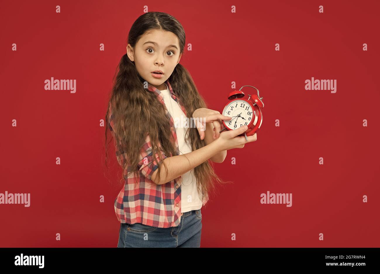 surprised kid girl showing time on vintage watch, alarm Stock Photo - Alamy