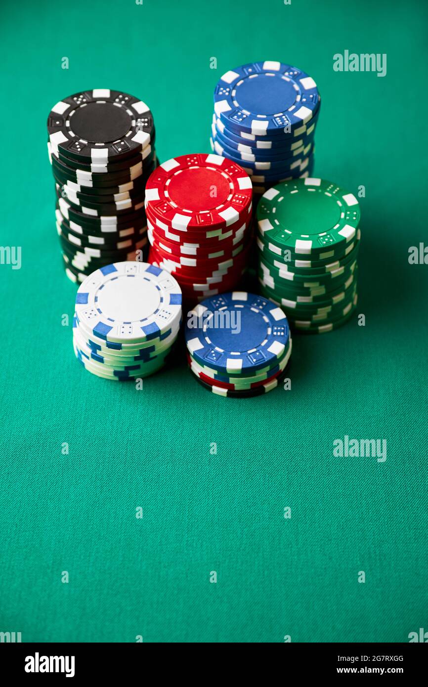 Stack of Casino gambling chips on green table Stock Photo - Alamy