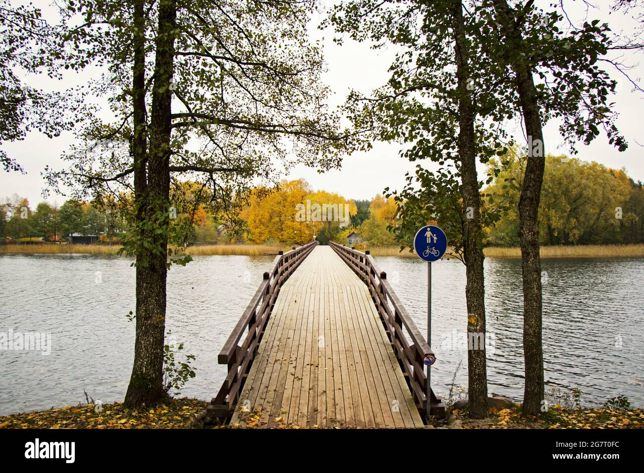 Beautiful wooden bridge over a large river in a fall park Stock Photo ...