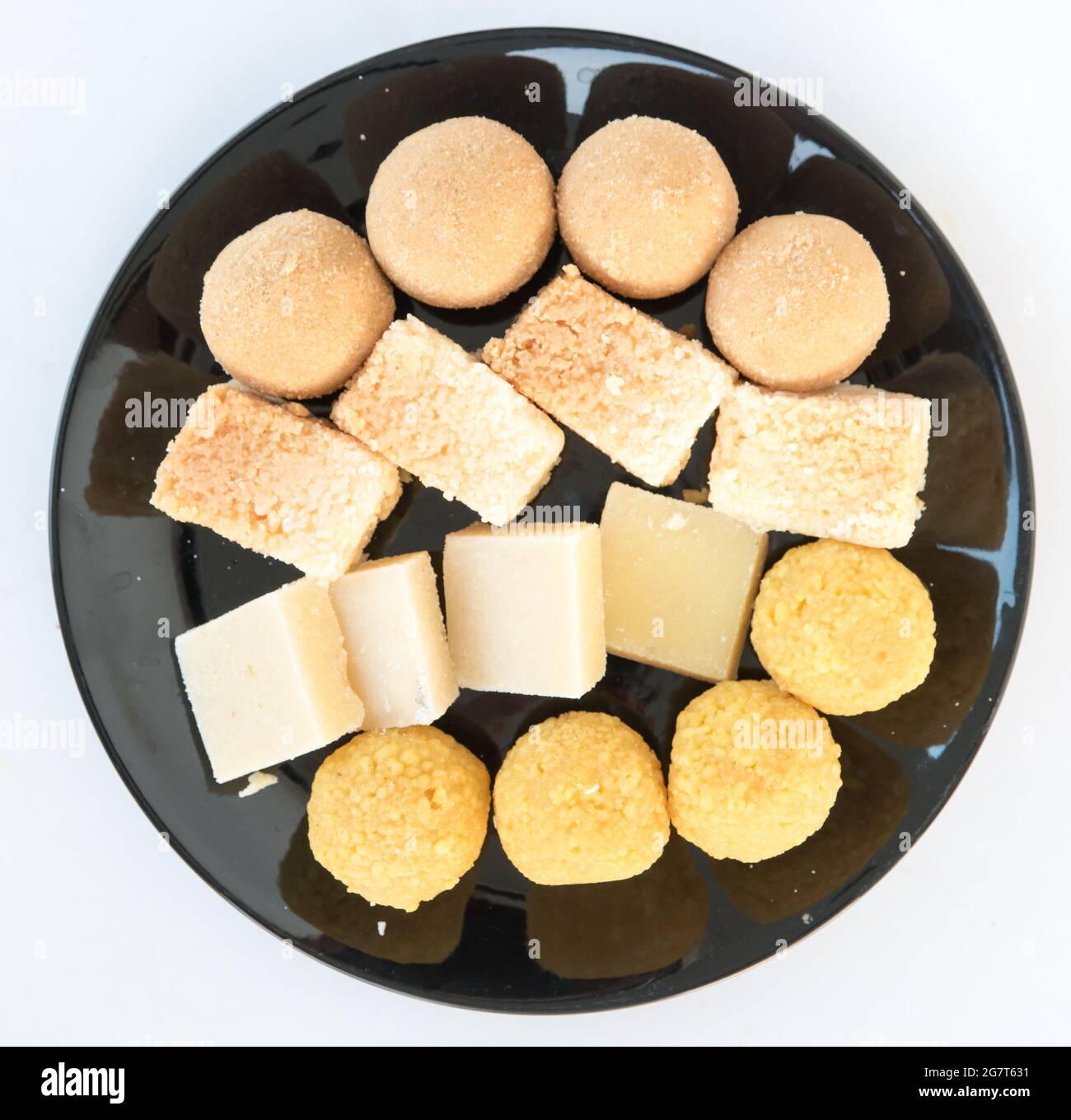 Top view of Indian sweets for Diwali, on a black plate on a white ...