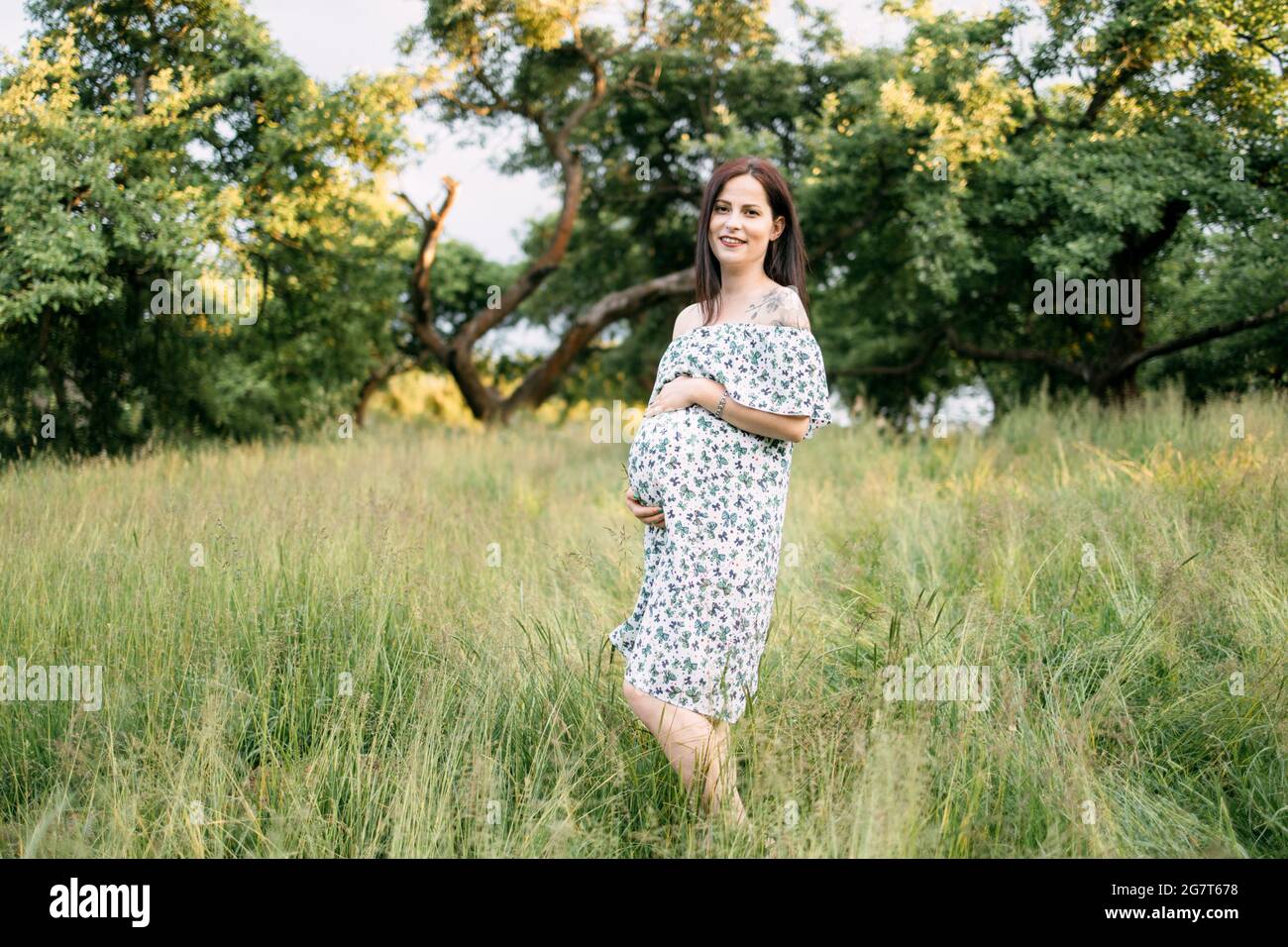 Pretty Caucasian Woman In Summer Dress Caressing Her Pregnant Belly