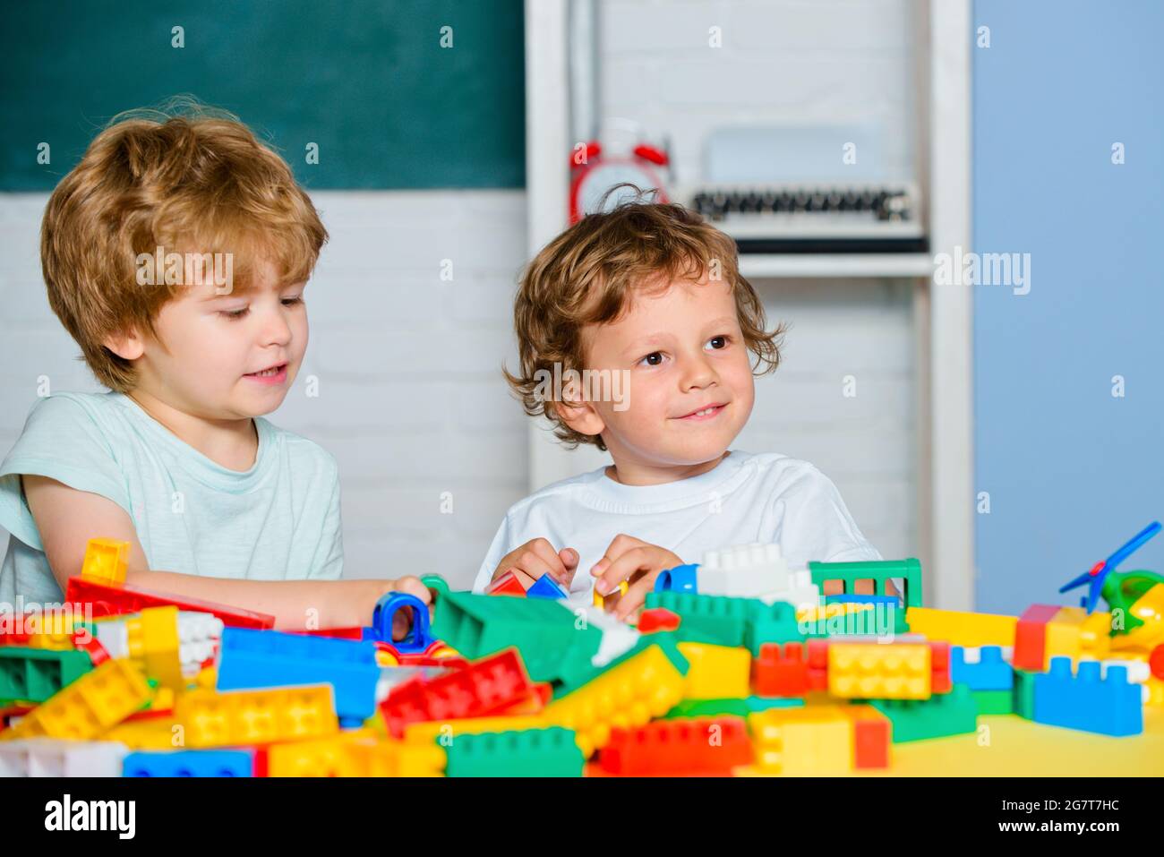 Toddler children play with blocks, trains and cars. Educational toys ...