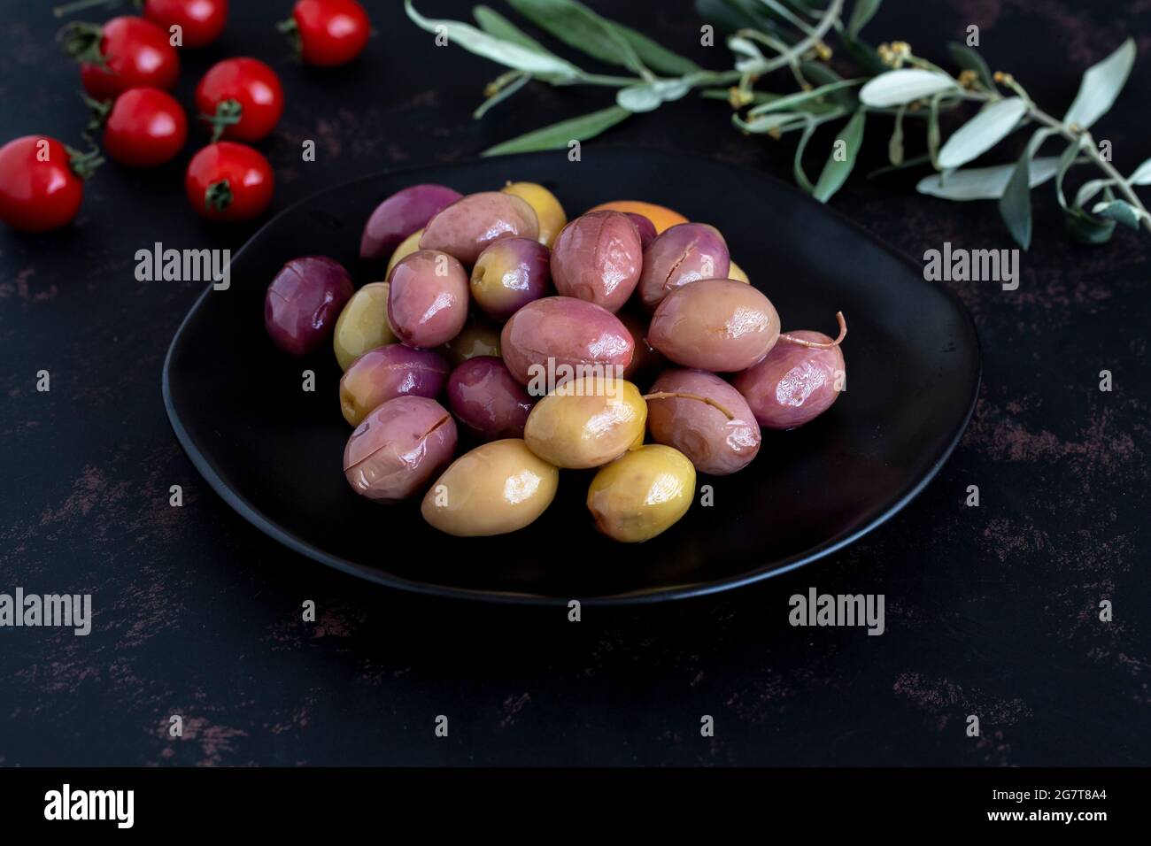 Mixed marinated olives (green and purple) on dark background. Tasty ...