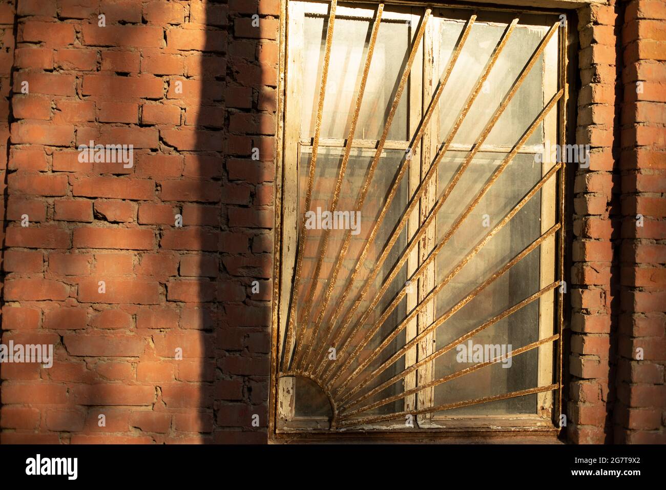 The window is behind bars. Window in an old house. Brickwork of a 19th ...