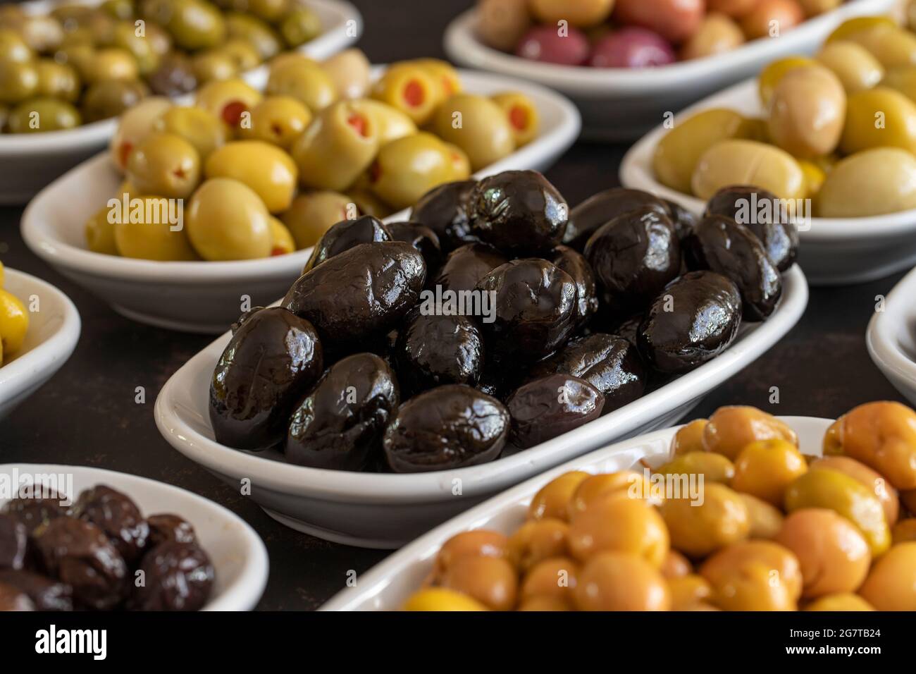 Assortment of olives on the plate in bulk. Organic black olives, Olive ...