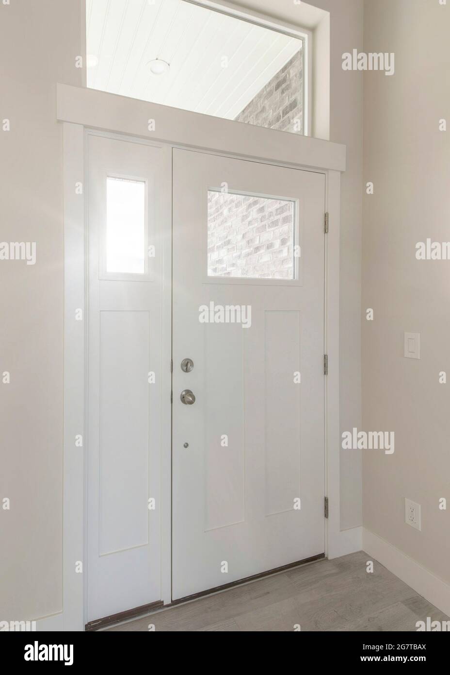 Vertical Interior of a white wooden front door with side panel and top ...