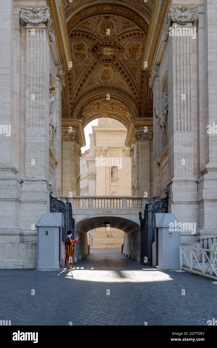 A Pontifical Swiss Guard wears a medical mask while guarding access to ...