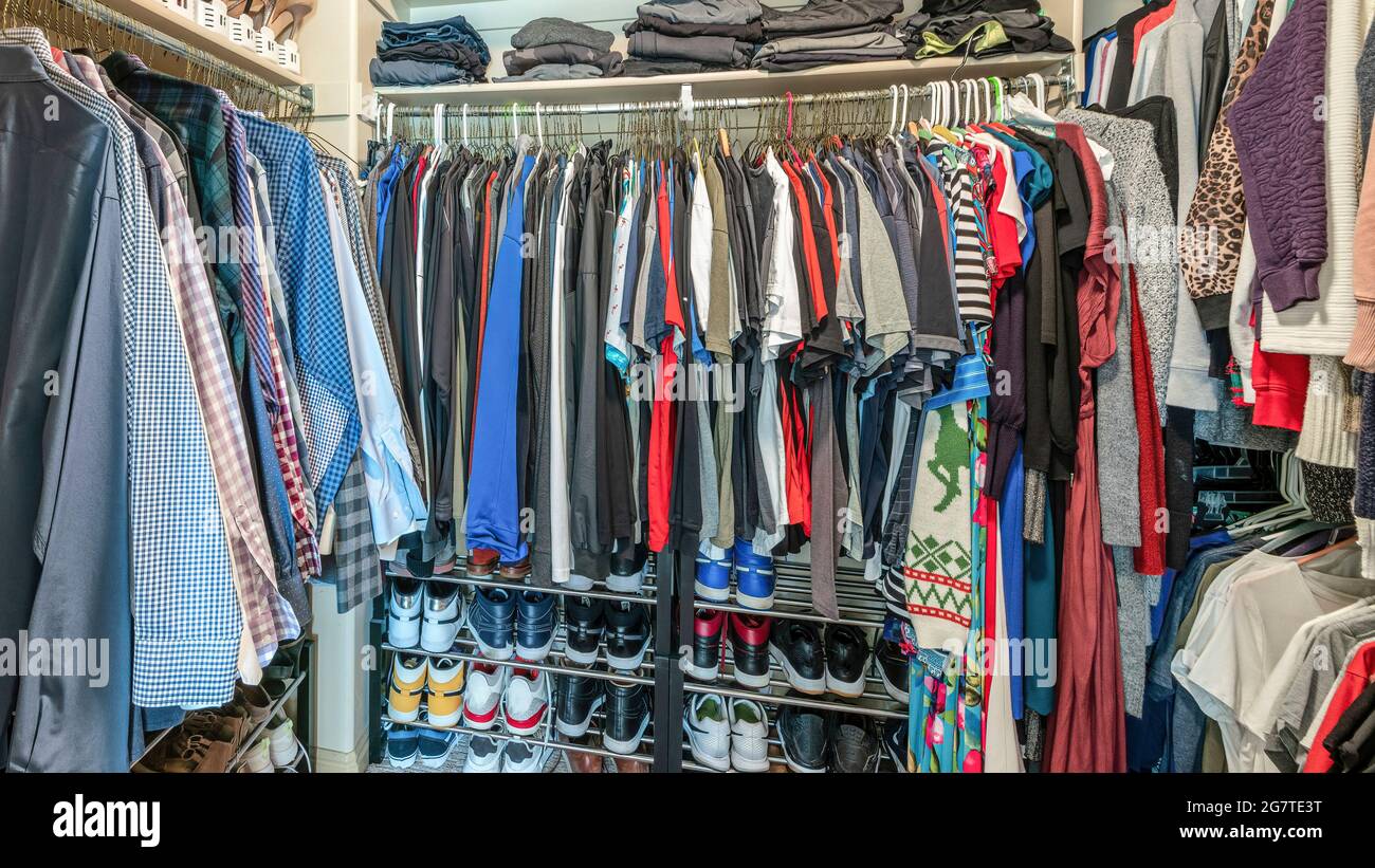 Pano Small walk in closet with hanging rods and shelves Stock Photo - Alamy