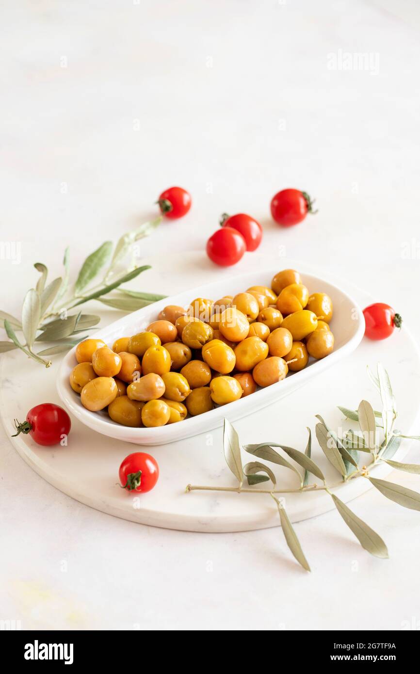 Scratched yellow olives. Tasty organic yellow olives in the plate ...