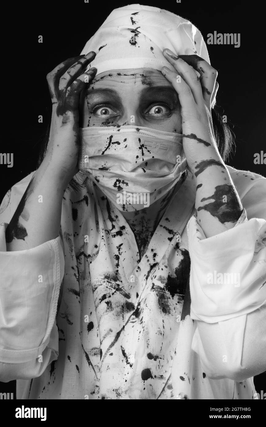 gloomy bloody woman doctor on a black background looking at camera ...