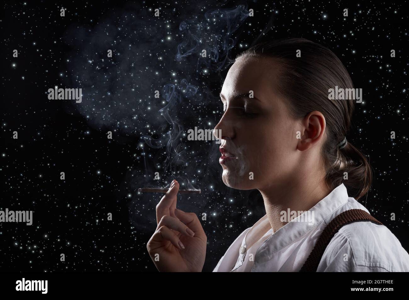 serious young woman smoking cigarette on stars sky background Stock ...