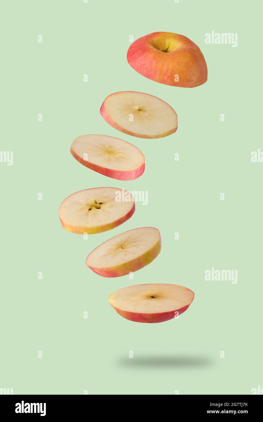Sliced red apple flying on light green background. Levitation of fruit ...