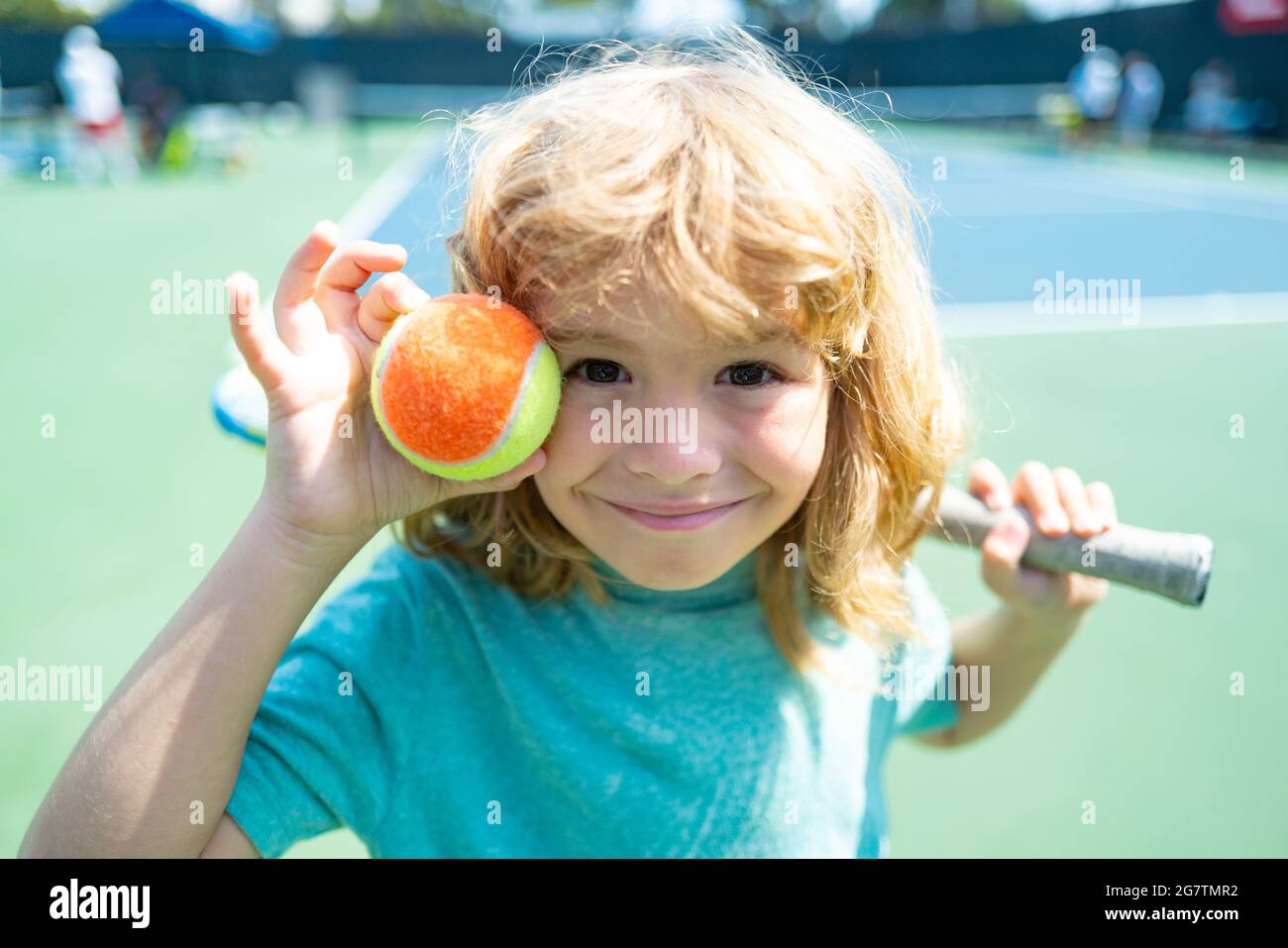 Child with tennis racket and ball on tennis court outdoor. Sport ...