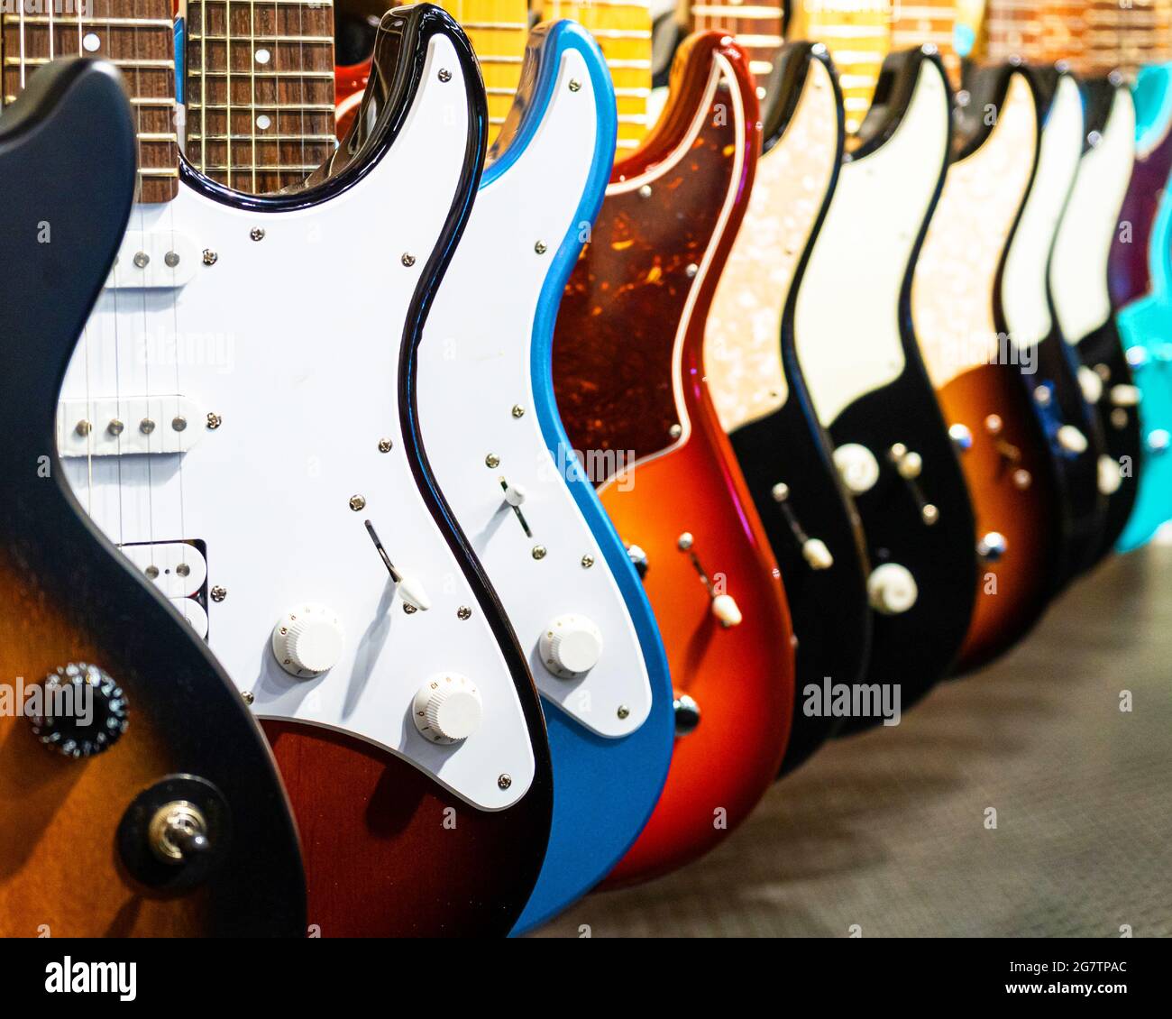 Row of electric guitars different color in a music instruments shop ...
