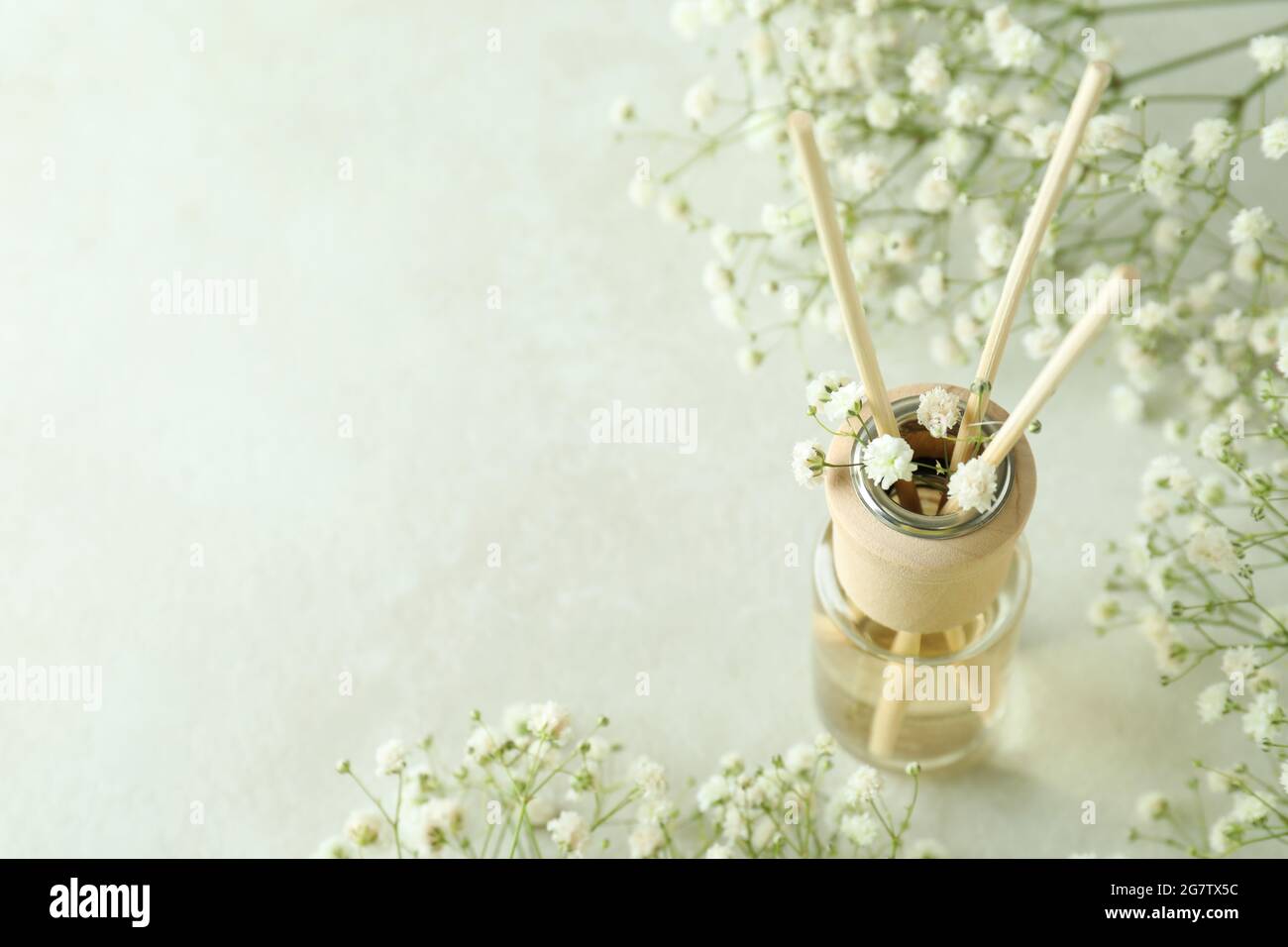 Diffuser and flowers on white textured table Stock Photo - Alamy