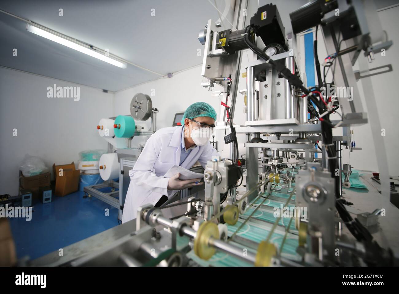 Quality control worker analyzing manufacturing machine in laboratory ...