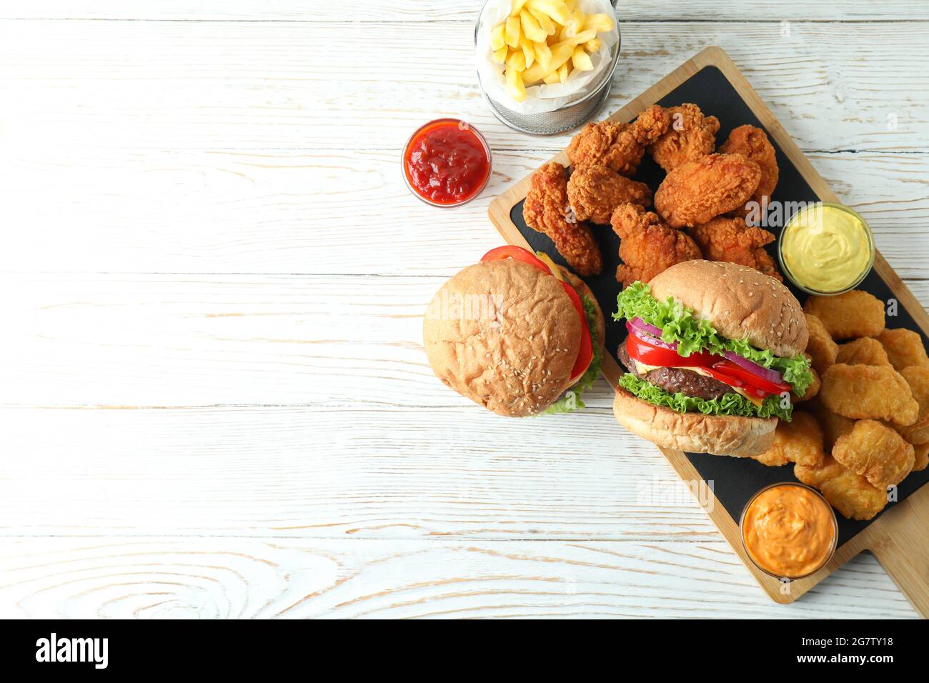 Concept of fast food on white wooden table Stock Photo - Alamy