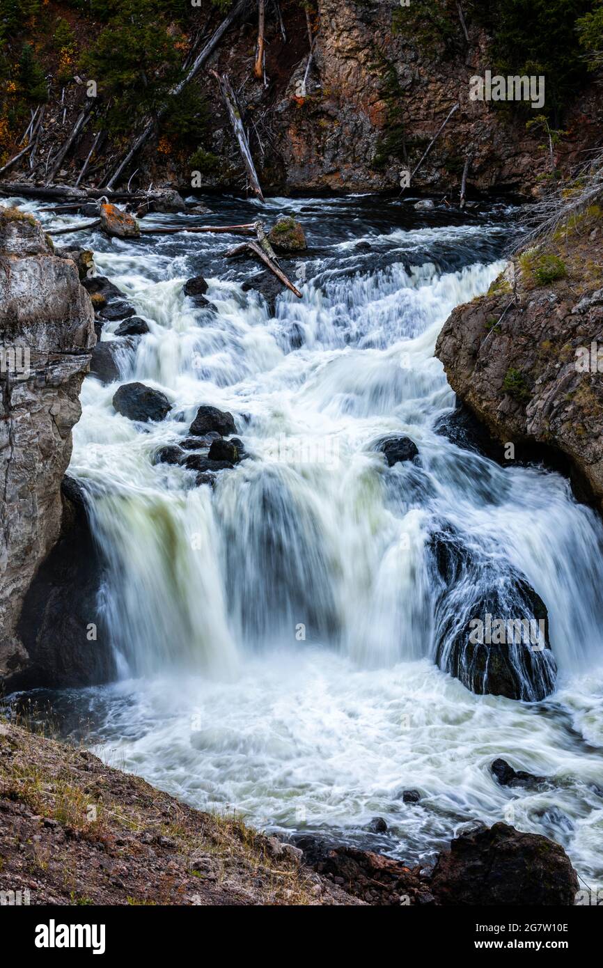 Blurry motion of flowing water of waterfall over black rock river Stock ...