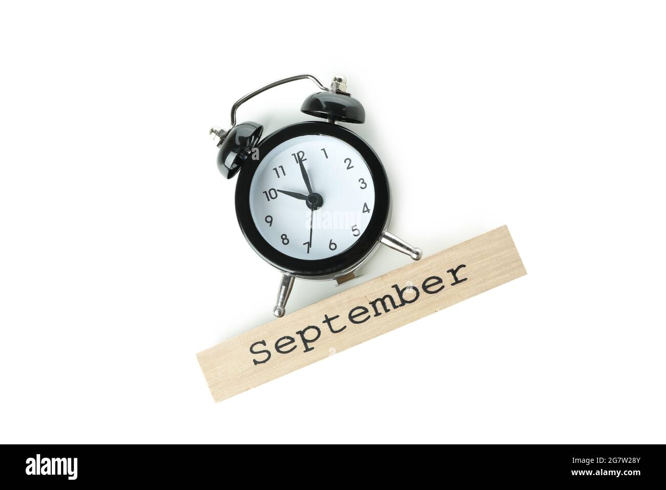 Alarm clock and wooden block with text September isolated on white ...