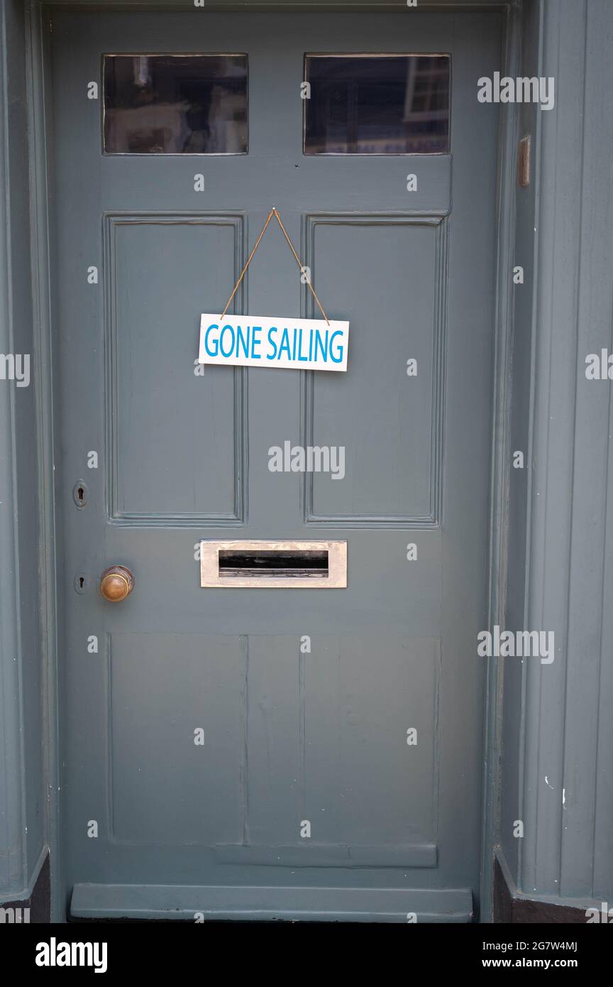 A grey front door with Gone sailing sign hung on the door Stock Photo ...