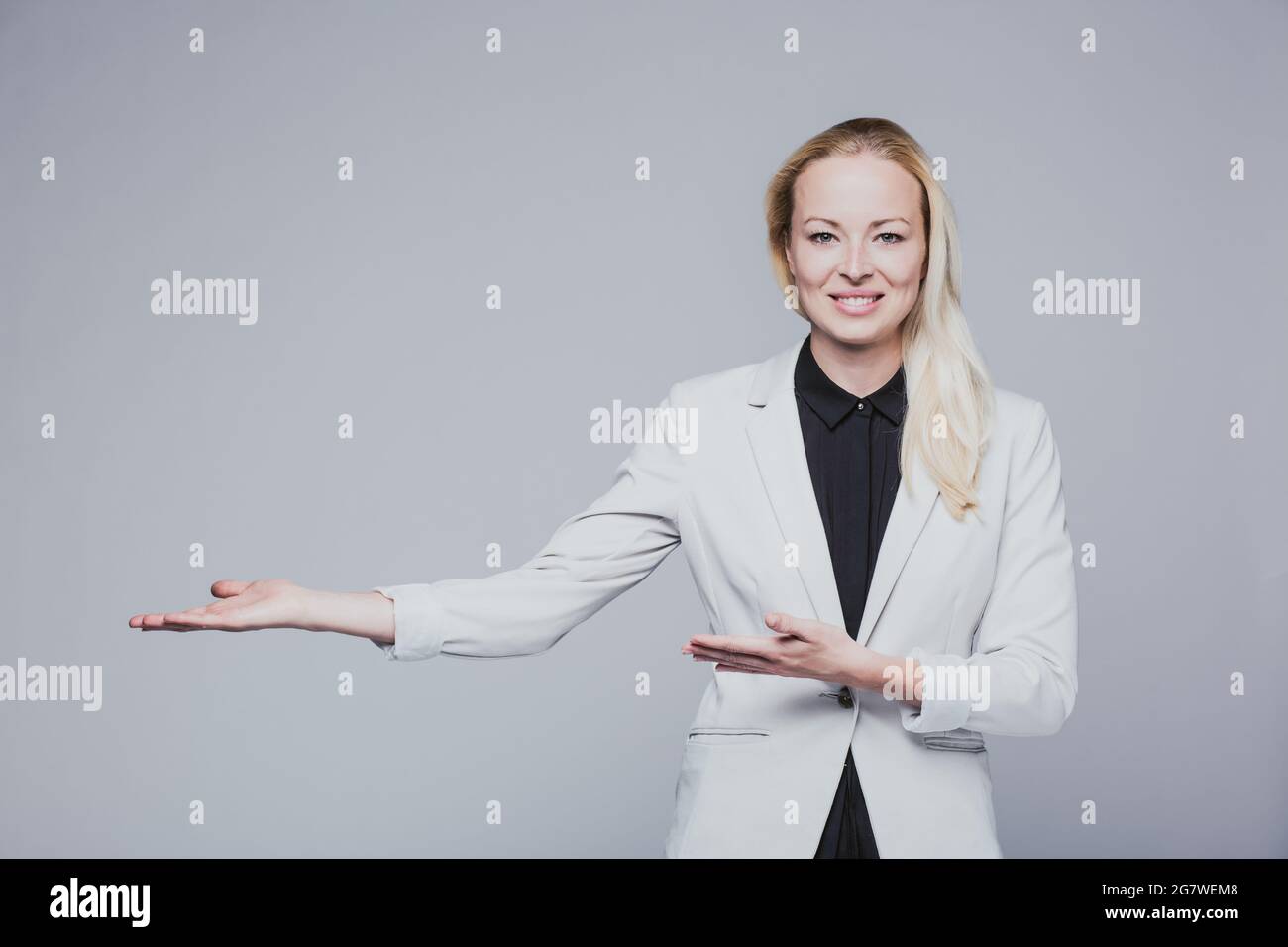 Business woman showing hand sign to side Stock Photo - Alamy