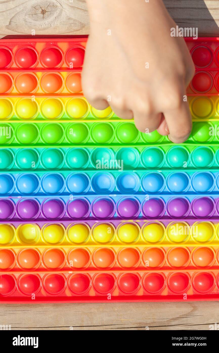 Baby fingers and antistress toy - popit, simple dimple Stock Photo - Alamy